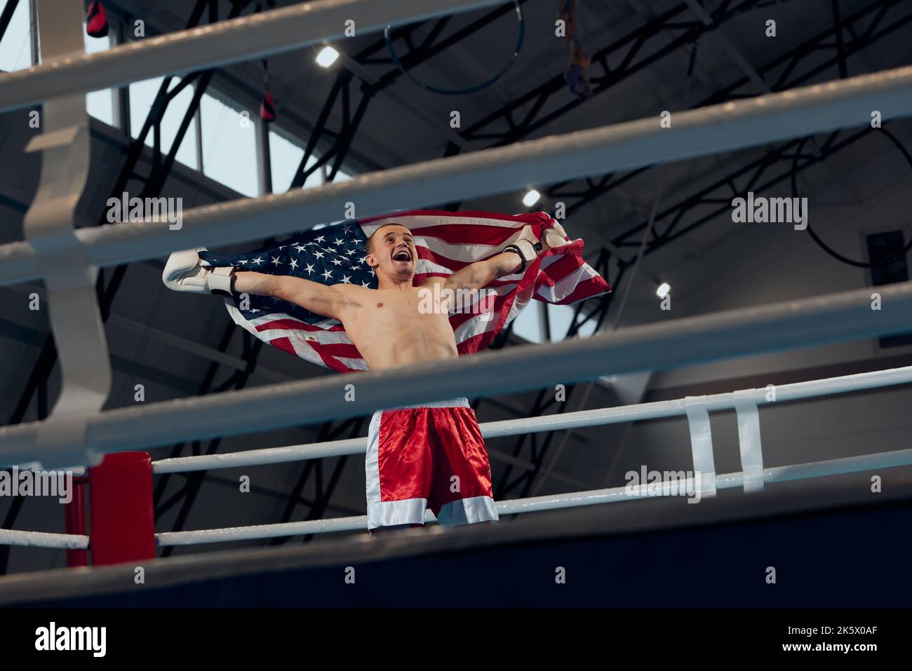 Winner emotions. Male boxer with american flag on his shoulders ...