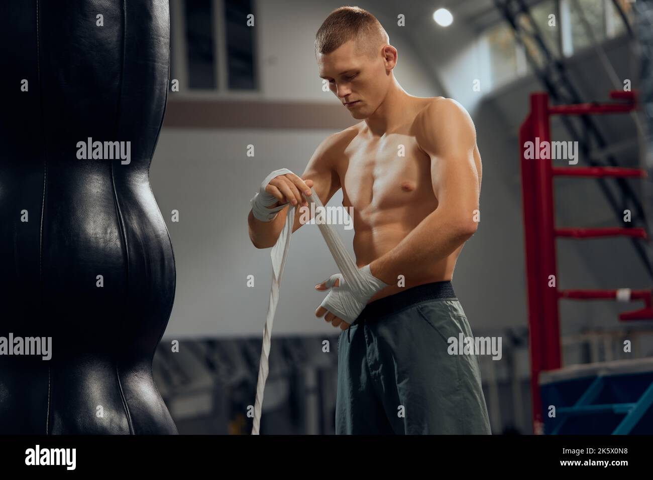 Male boxer wrapping his hands before fighting at sports gym, indoors ...