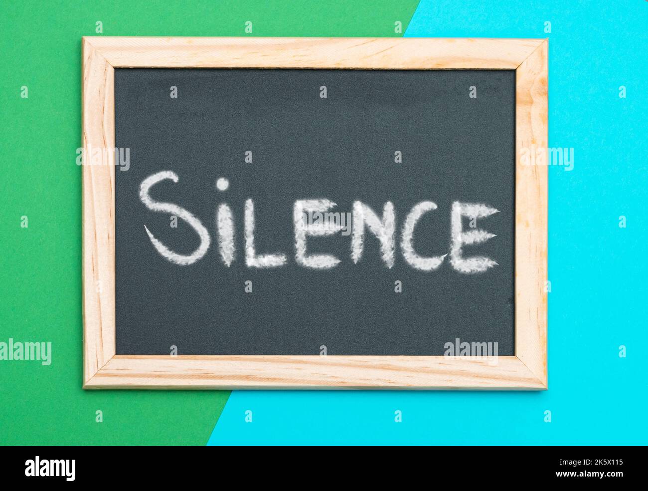 The blackboard with 'Silence' writing, on a green and blue wall Stock ...