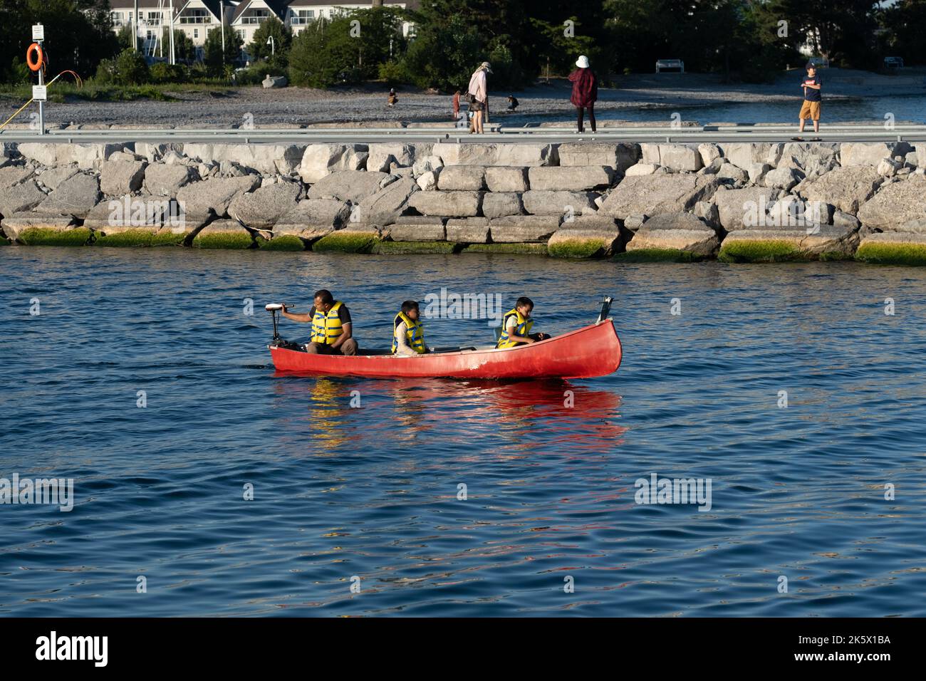 A few passengers aboard a red canoe on the water Stock Photo - Alamy