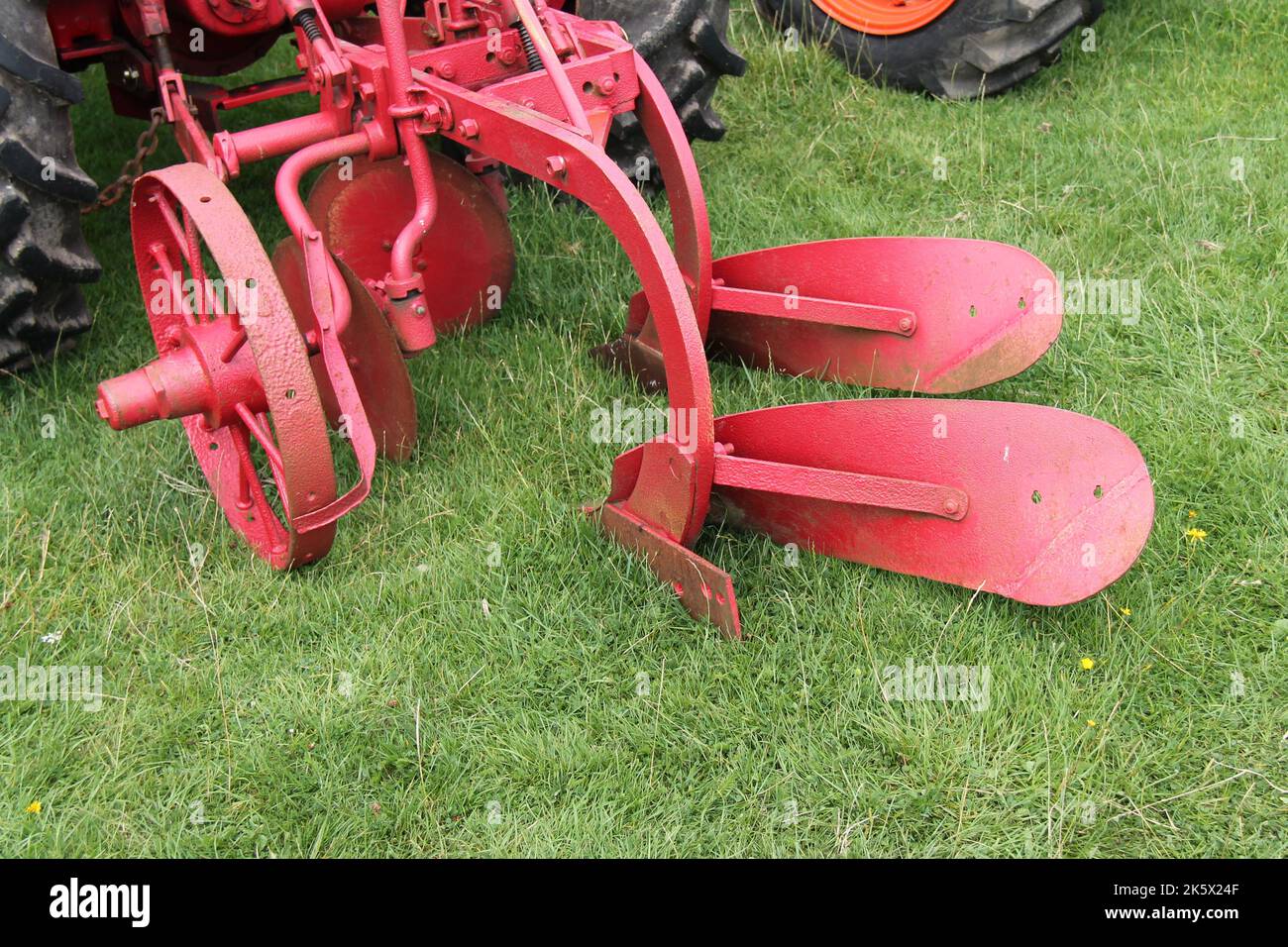 A Classic Old Plough Attached to a Farming Tractor Stock Photo - Alamy
