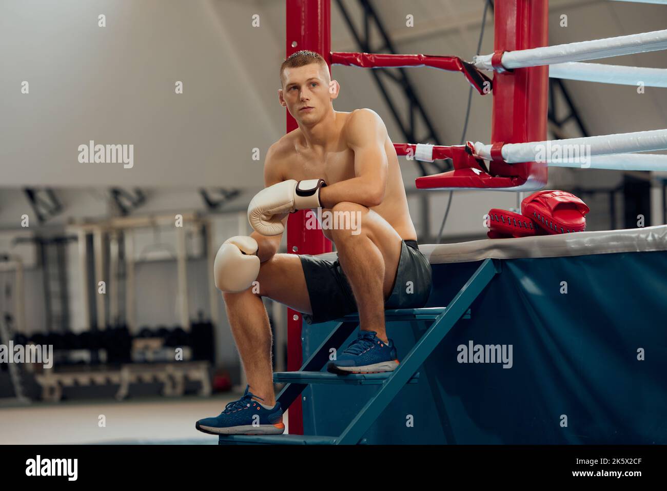 Young athlete, male boxer on break from exercise and training on the ...