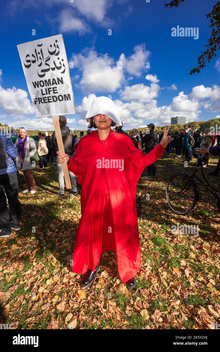 A protester dressed in red holds a placard during the demonstration on ...