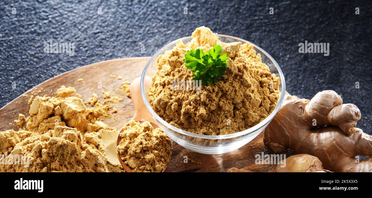 A bowl with ground ginger and its fresh rhizome Stock Photo - Alamy