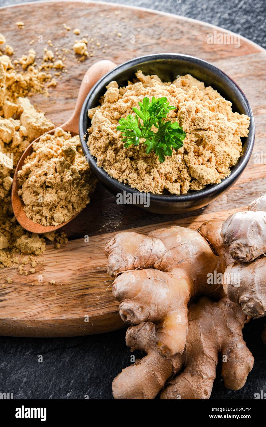 A bowl with ground ginger and its fresh rhizome Stock Photo - Alamy