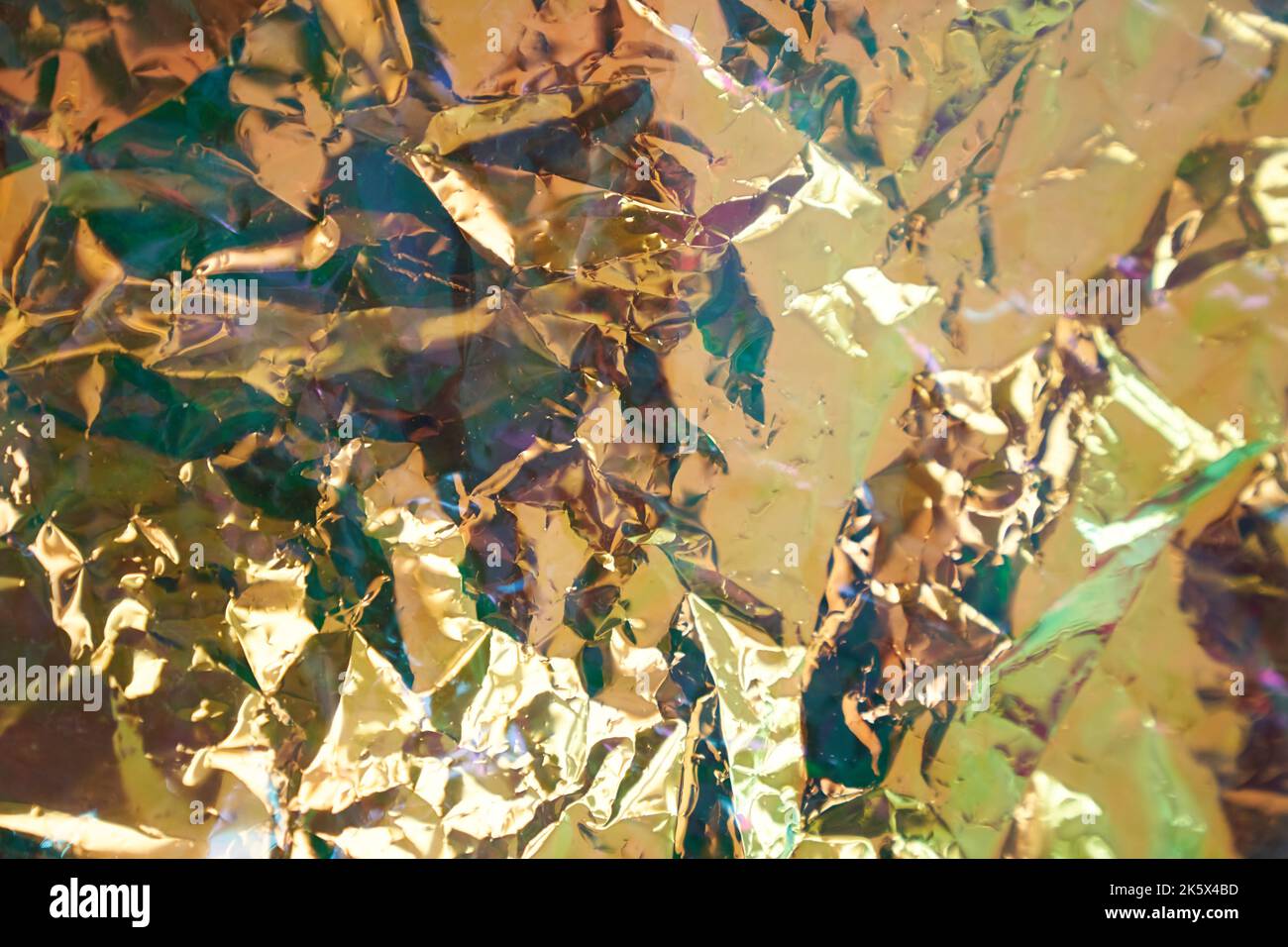 Holographic colored wrinkled yellow foil. Holographic texture of real ...