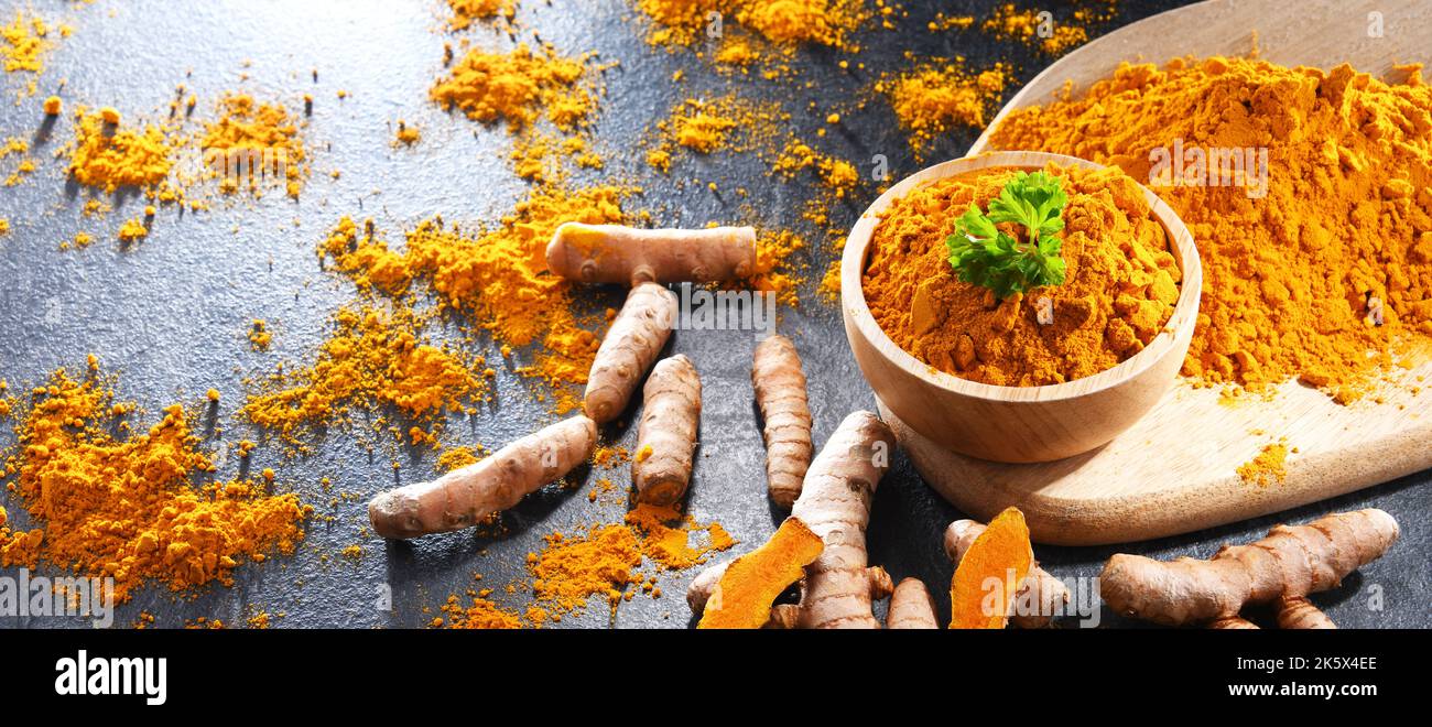 Composition with a bowl of ground turmeric and its fresh rhizome Stock ...