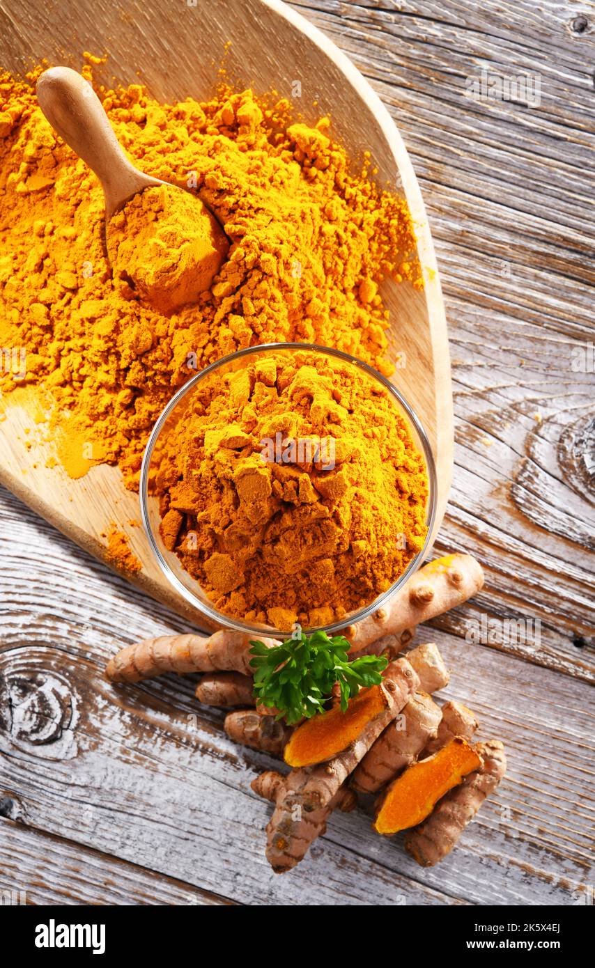 Composition with a bowl of ground turmeric and its fresh rhizome Stock ...