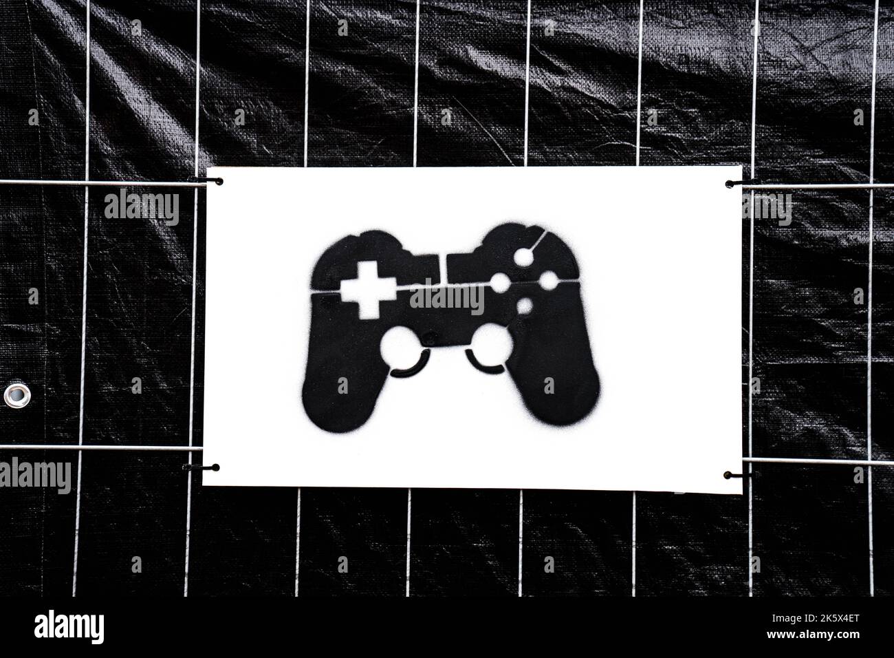 A black video game controller sign on white background on the wall ...