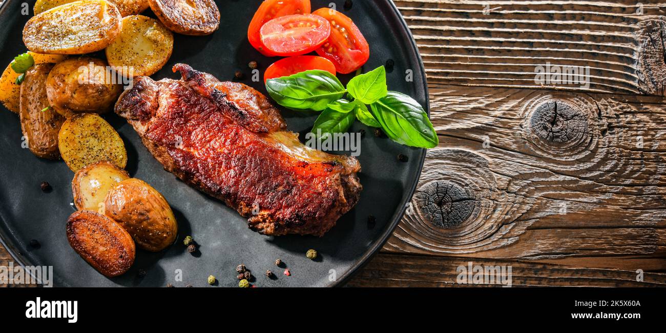 Pan-fried beef steak with fried potatoes and cherry tomatoes Stock ...