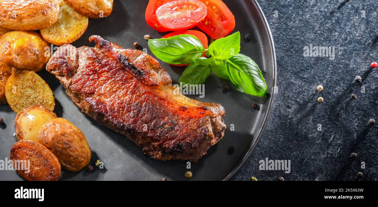Pan-fried beef steak with fried potatoes and cherry tomatoes Stock ...