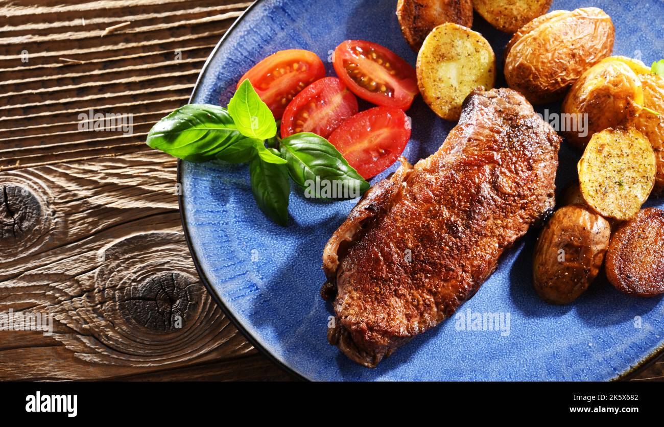 Pan-fried beef steak with fried potatoes and cherry tomatoes Stock ...