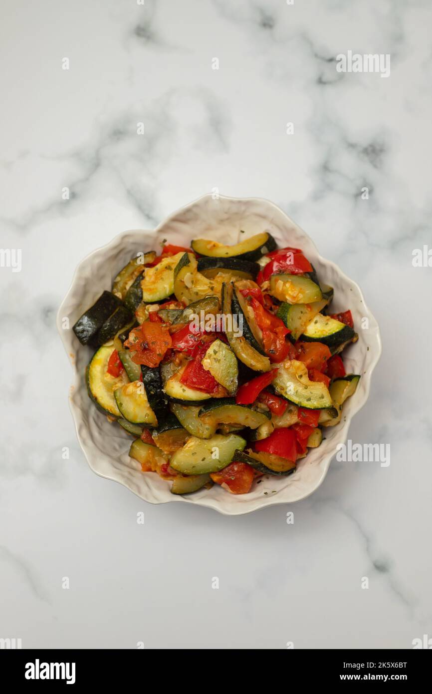 baked vegetables curgette, tomato and pepper in white small beautiful ...
