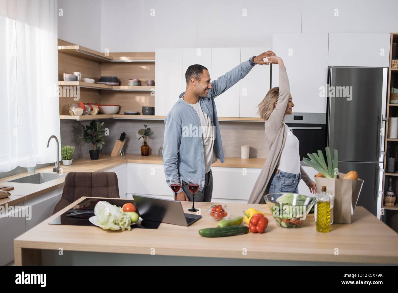Young attractive couple of man and woman cooking breakfast together in ...