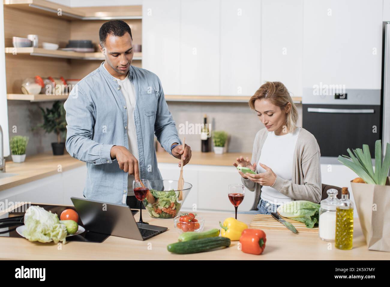 Couple cooking together using a recipe hi-res stock photography and ...