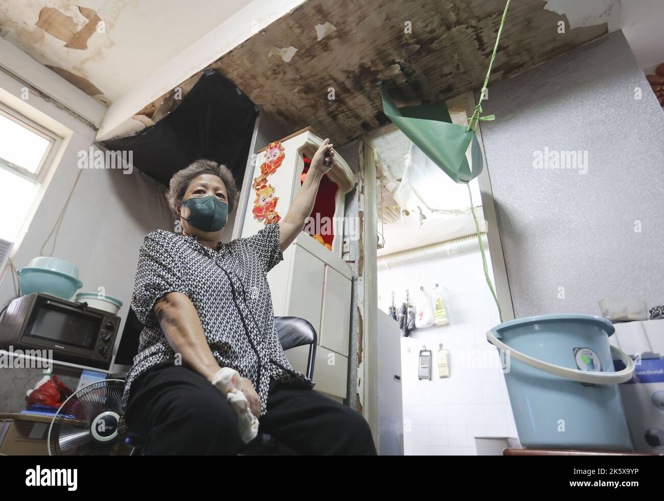 Mrs Ng points at the damaged part of her flat at Ming Lun Street in To ...
