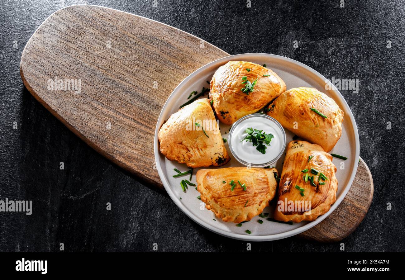 Composition with a plate of oven-baked pierogi Stock Photo - Alamy