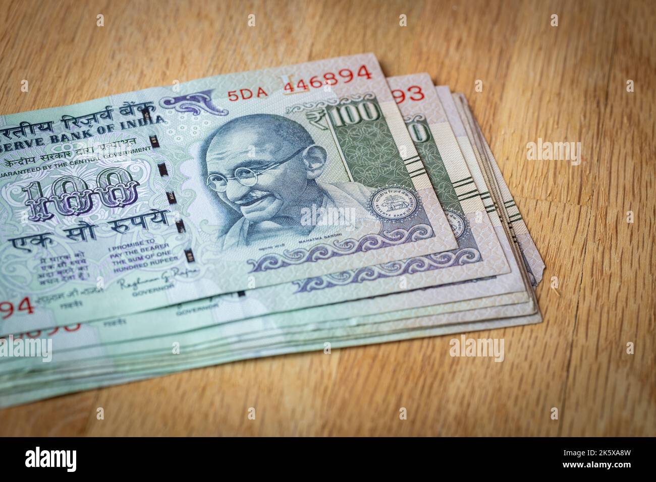 a bundle of banknotes of 100 Indian rupees lying on the table Stock ...
