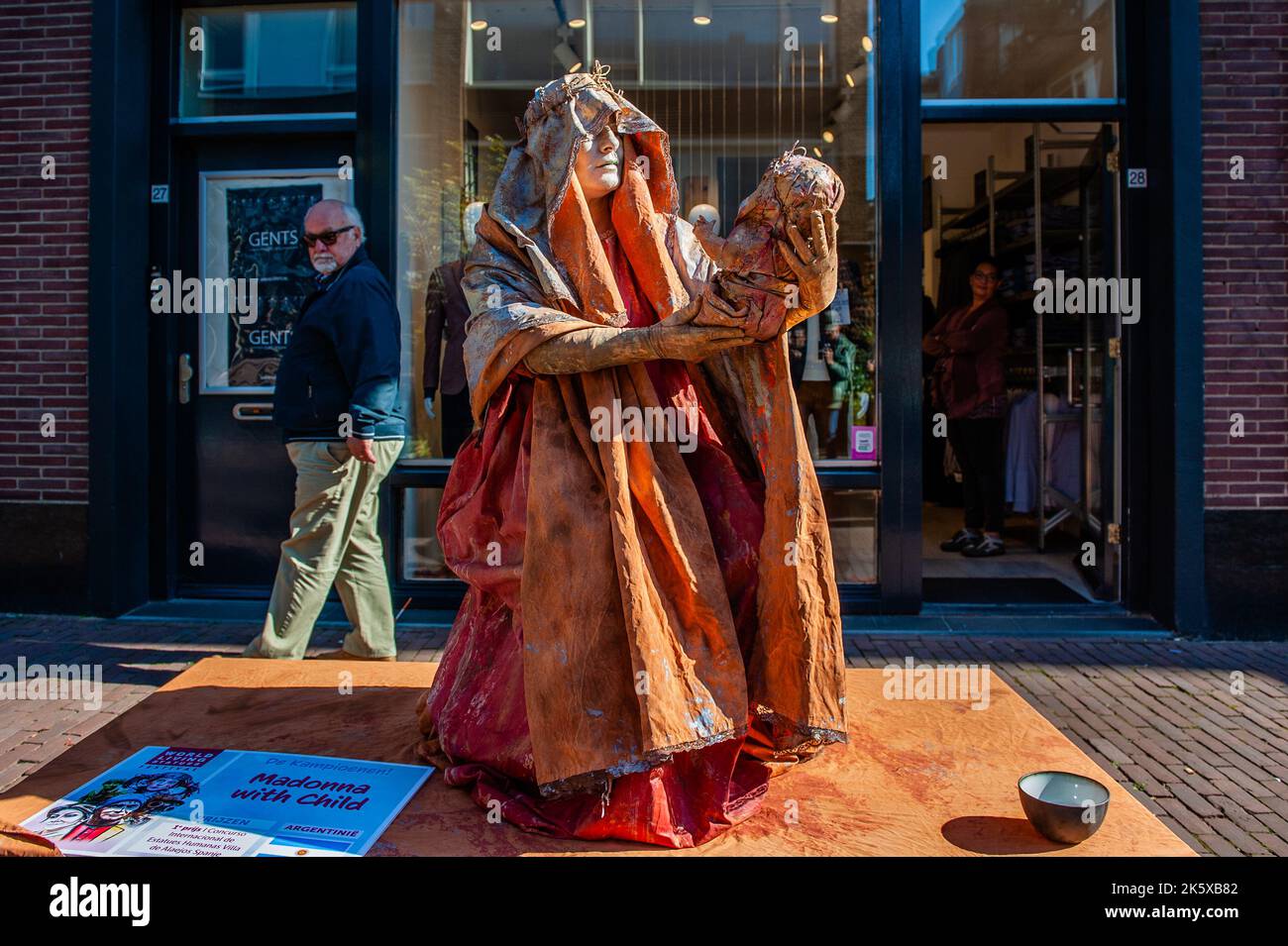 A female artist is seen performing as a living statue dressed like a ...