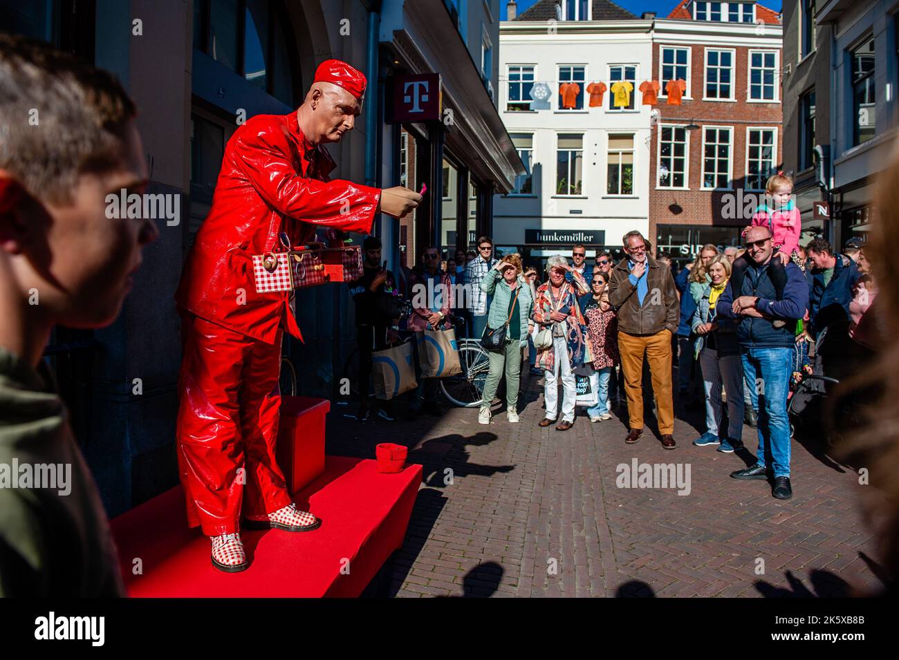 An artist is seen performing as a living statue dressed like a candy ...