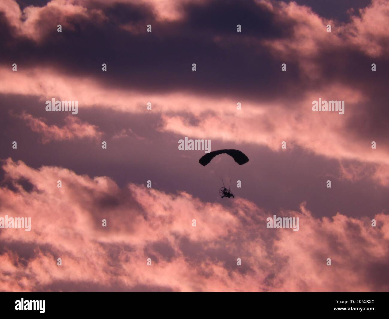 A mesmerizing scene of Paragliding in the dramatic sunset sky with ...