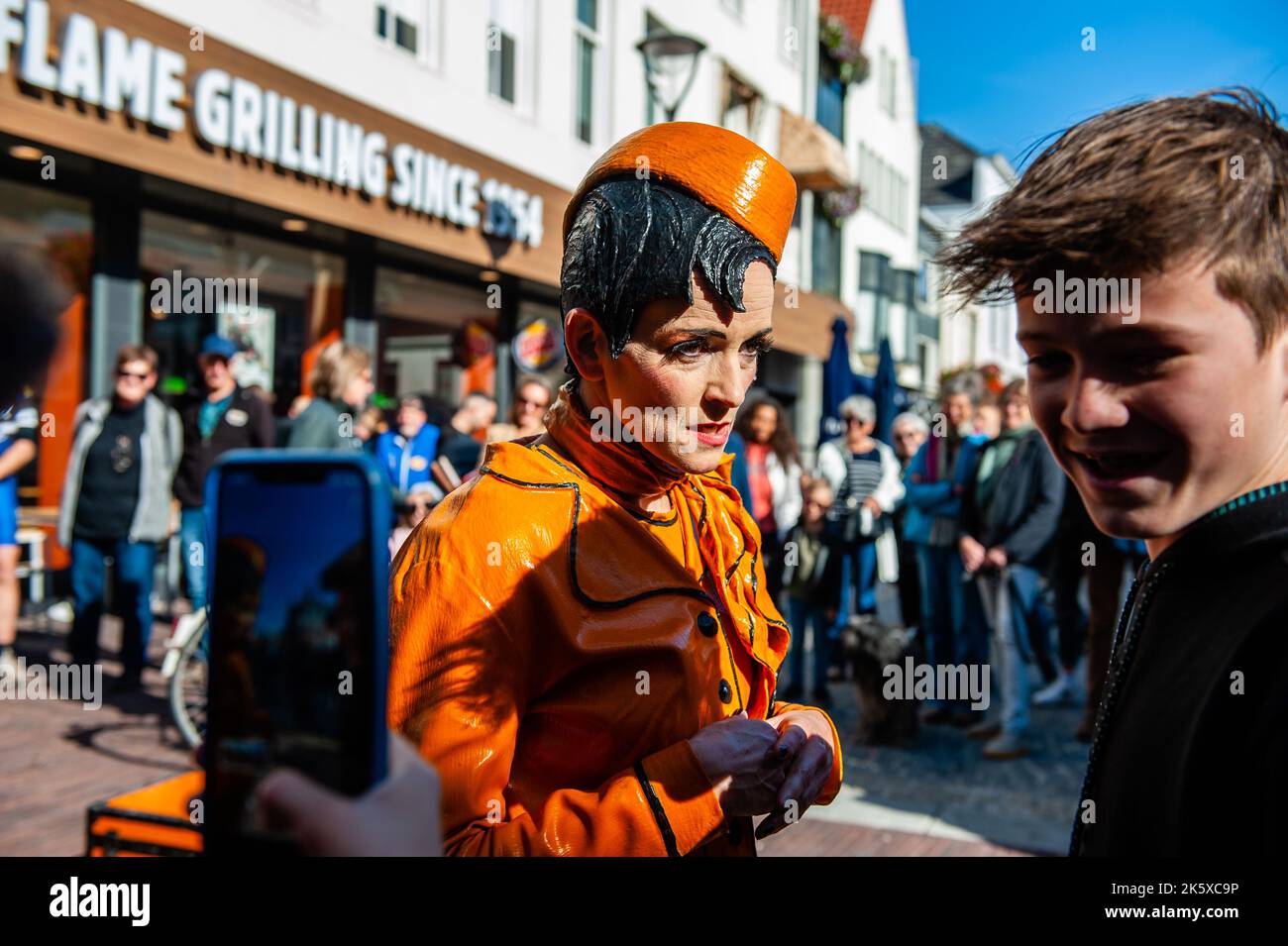 A female artist performing as a living statue is seen interacting with ...