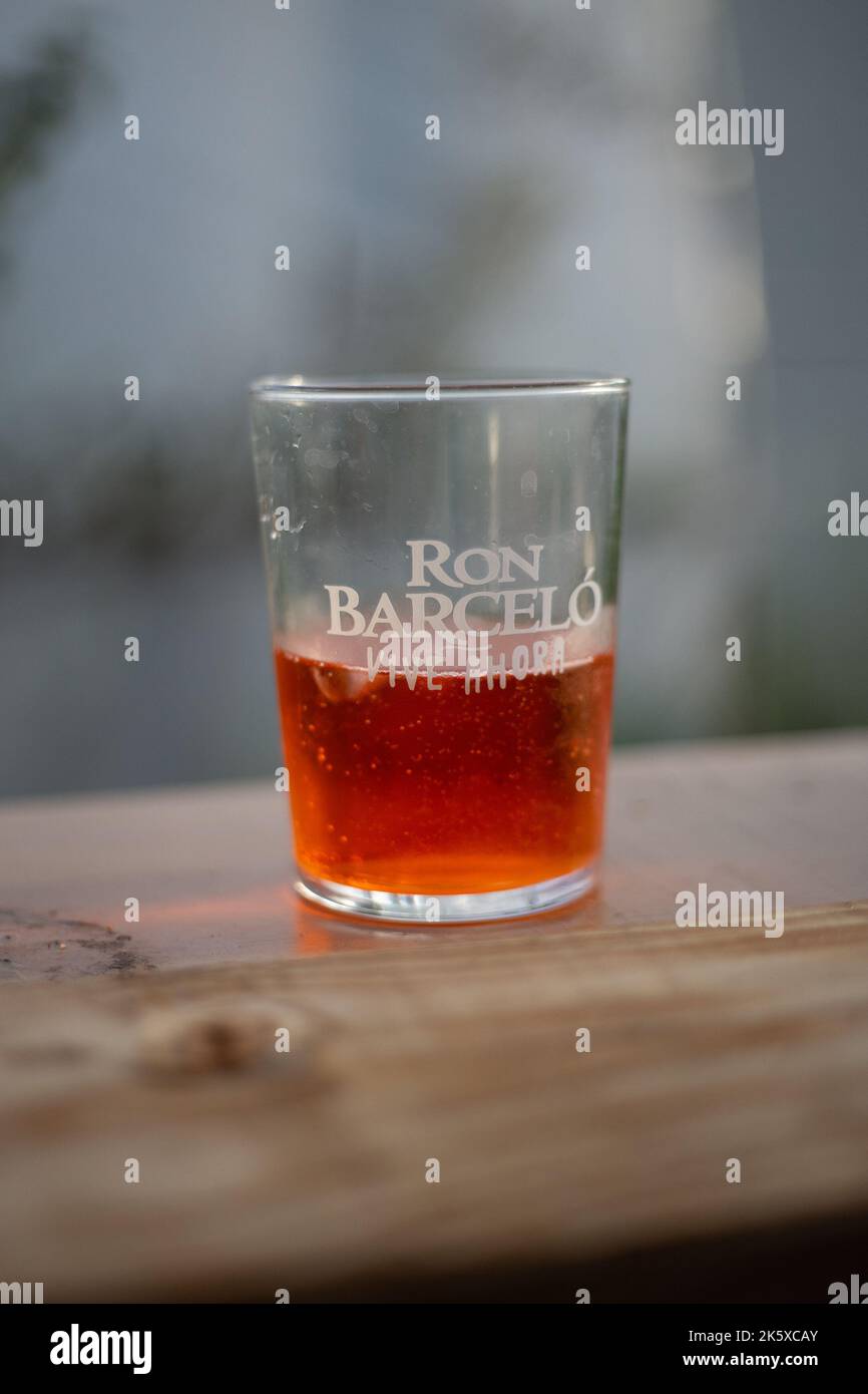 A vertical selective focus of a red Ron Barcelo Anejo Rum in the glass ...