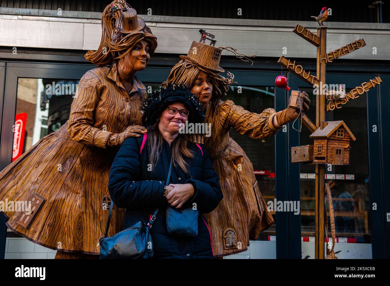 A woman is seen posing with two female living statues. The World Living ...