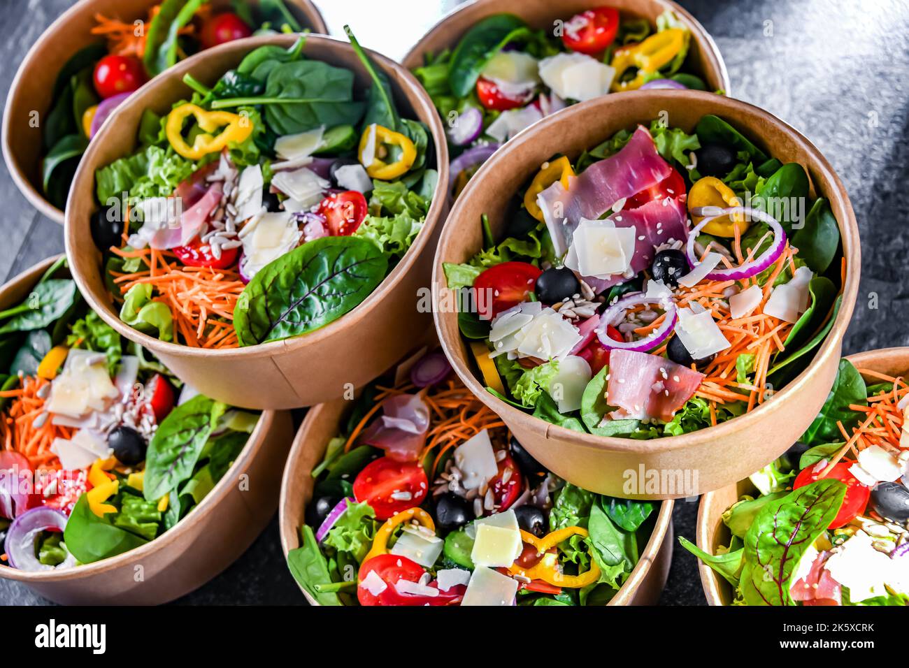 Round paper boxes with pre-packaged vegetable salads ready for sale ...