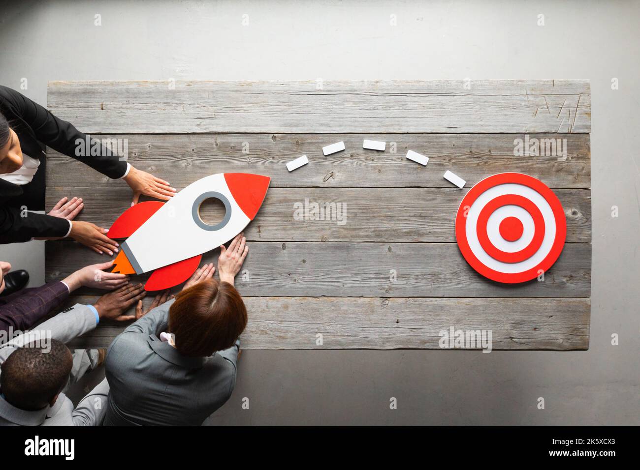 Team of business people with rocket as a sumbol of high risky goals ...