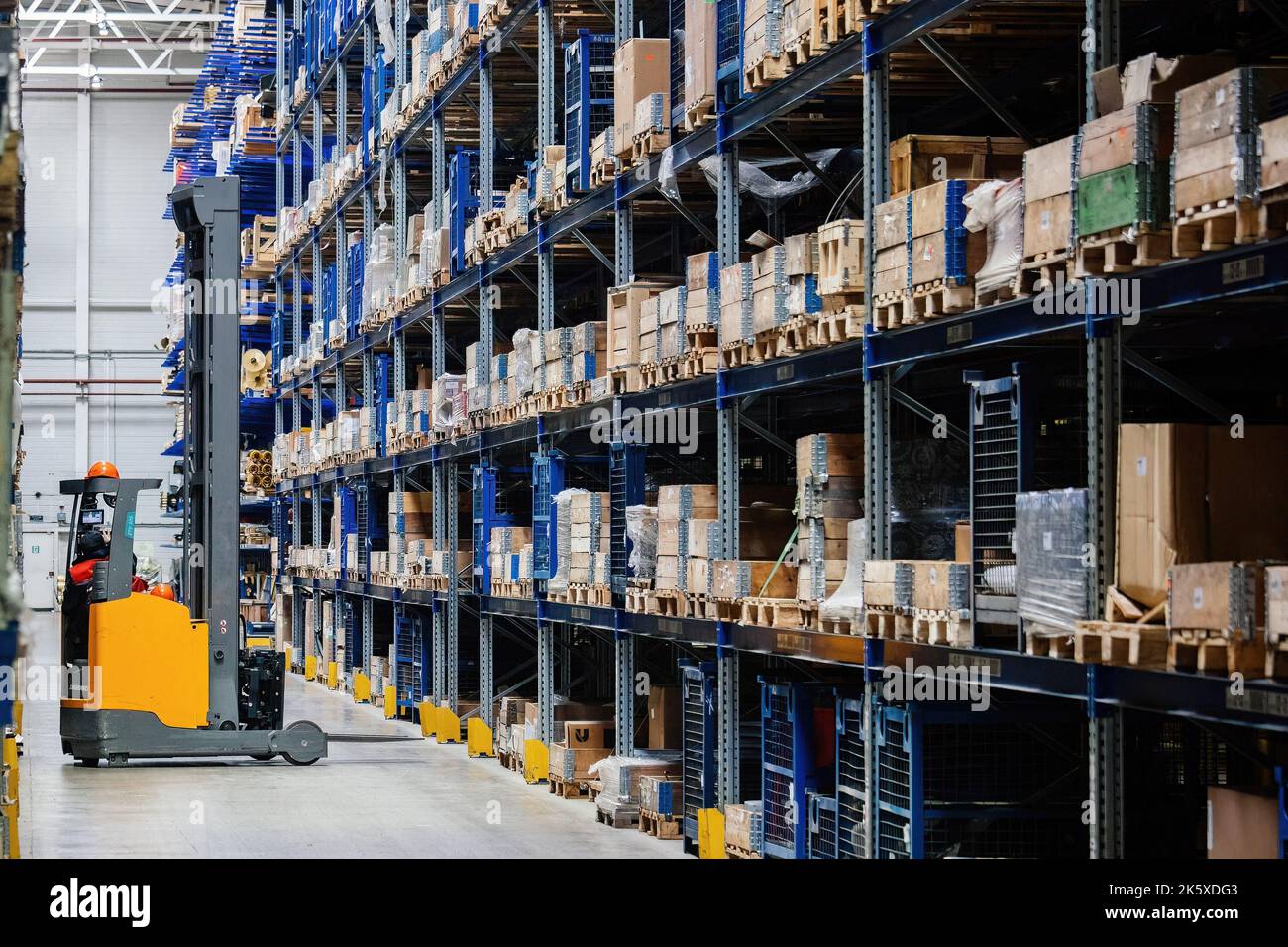 Modern warehouse interior with shelves and boxes and forklift loader ...