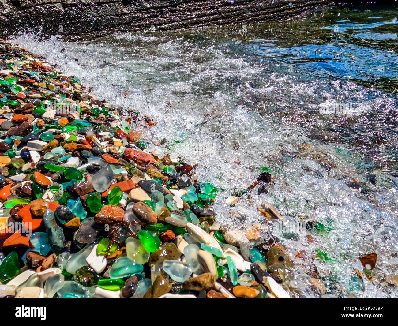 Natural polish textured sea glass and stones on the seashore. Azure ...