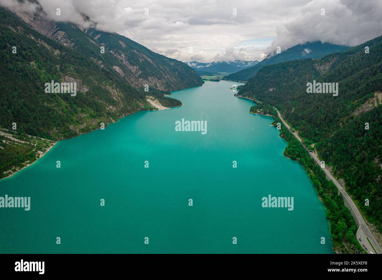 An aerial view of Achen Lake between lush green steep mountains in ...