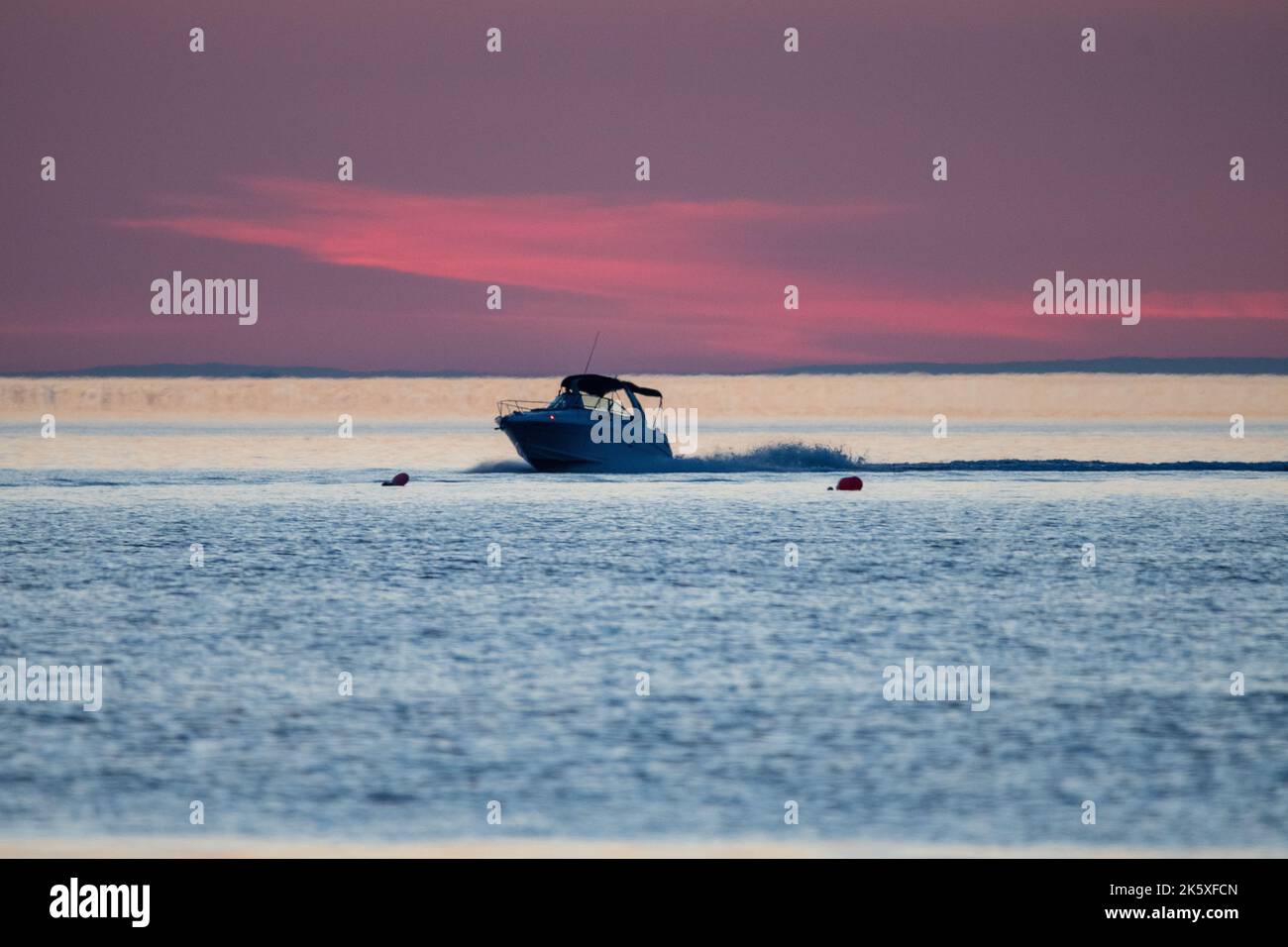 A closeup of a small boat on the sea against a background of ...