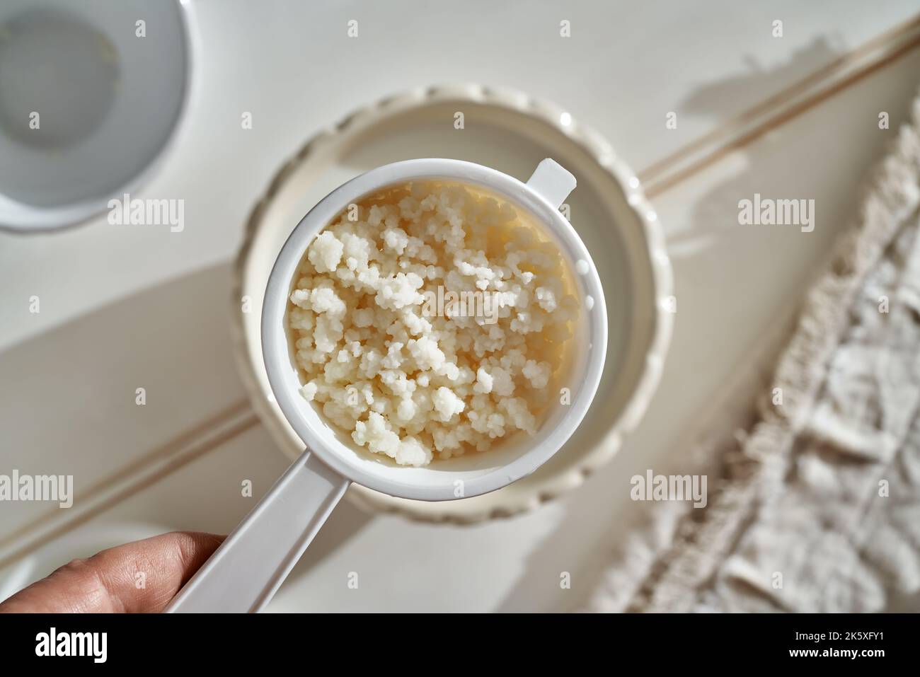 Fresh kefir grains in a white strainer - preparation of homemade ...