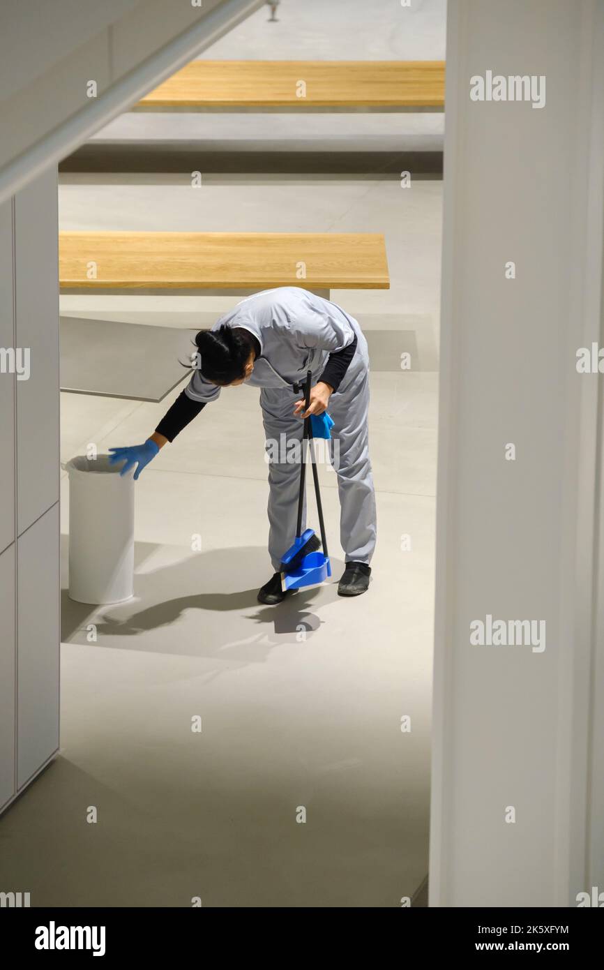Woman in cleaning uniform working in corporate building Stock Photo - Alamy