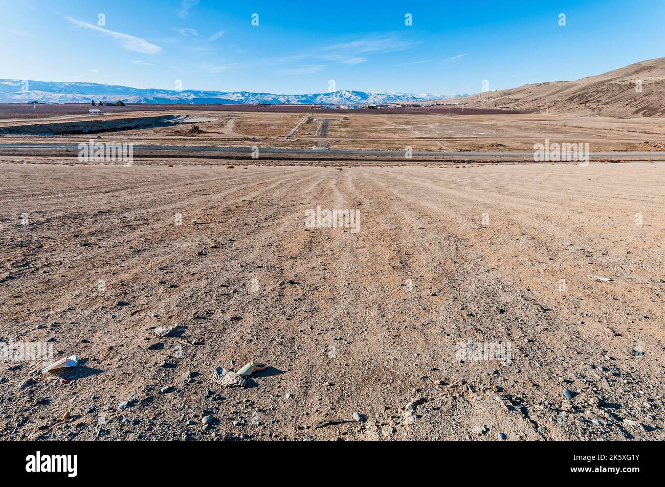 An asphalt road stretches across a vast active solid-waste landfill ...