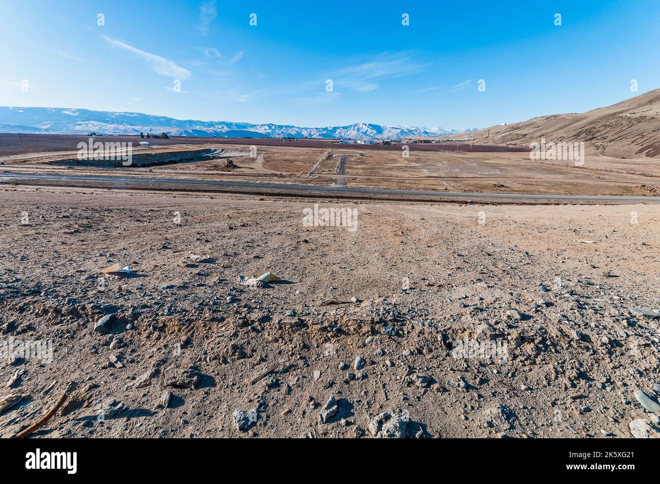 An asphalt road stretches across a vast active solid-waste landfill ...