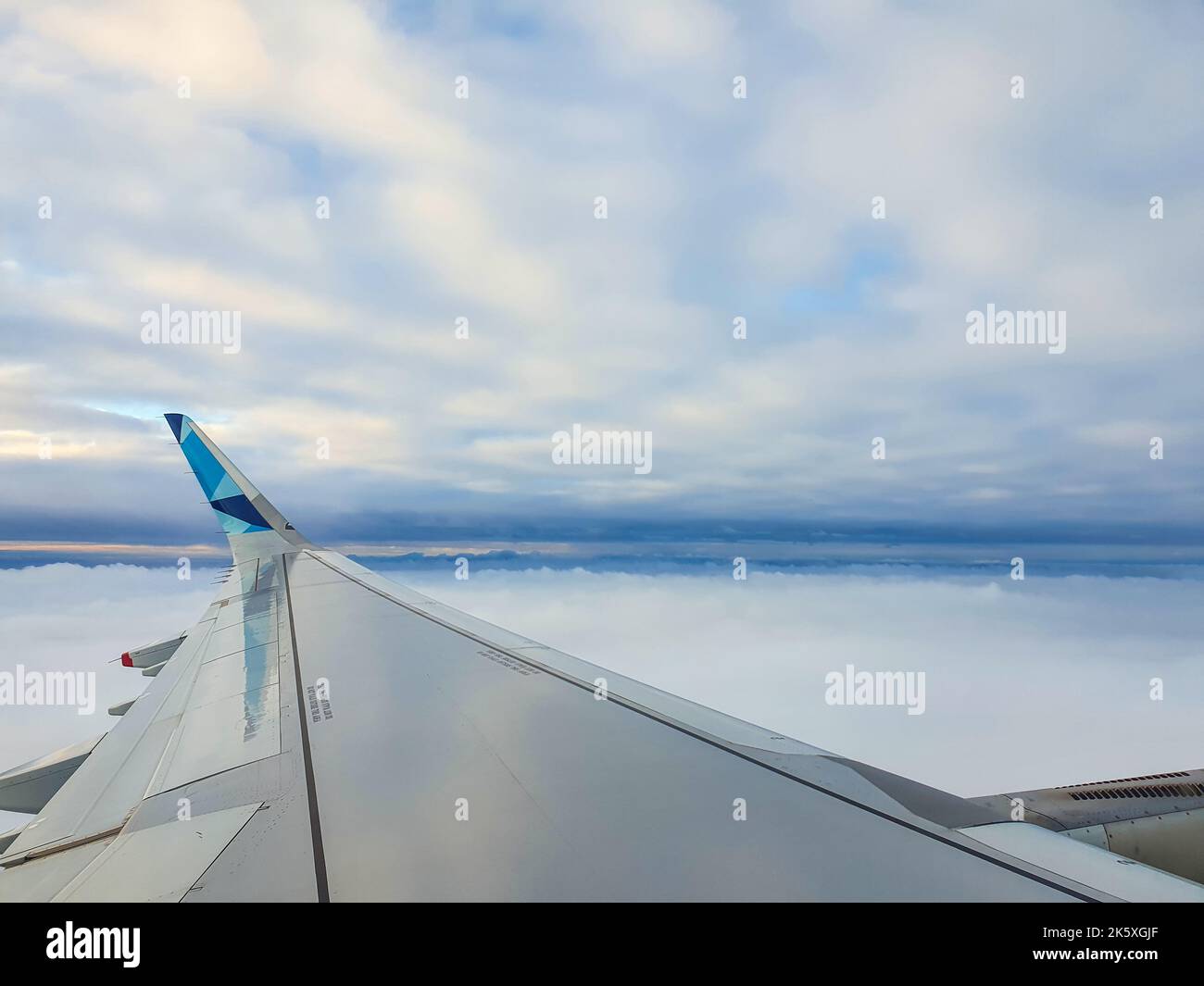 The wing and view from a plane window between two layers of cloud Stock ...