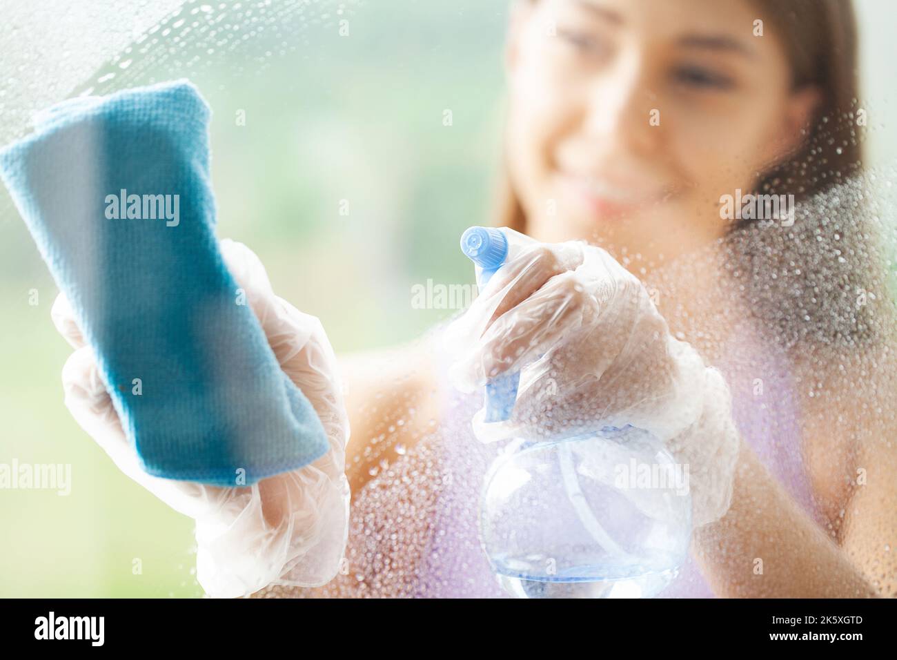 Young Smiling Woman Washing Window with Sponge Stock Photo - Alamy