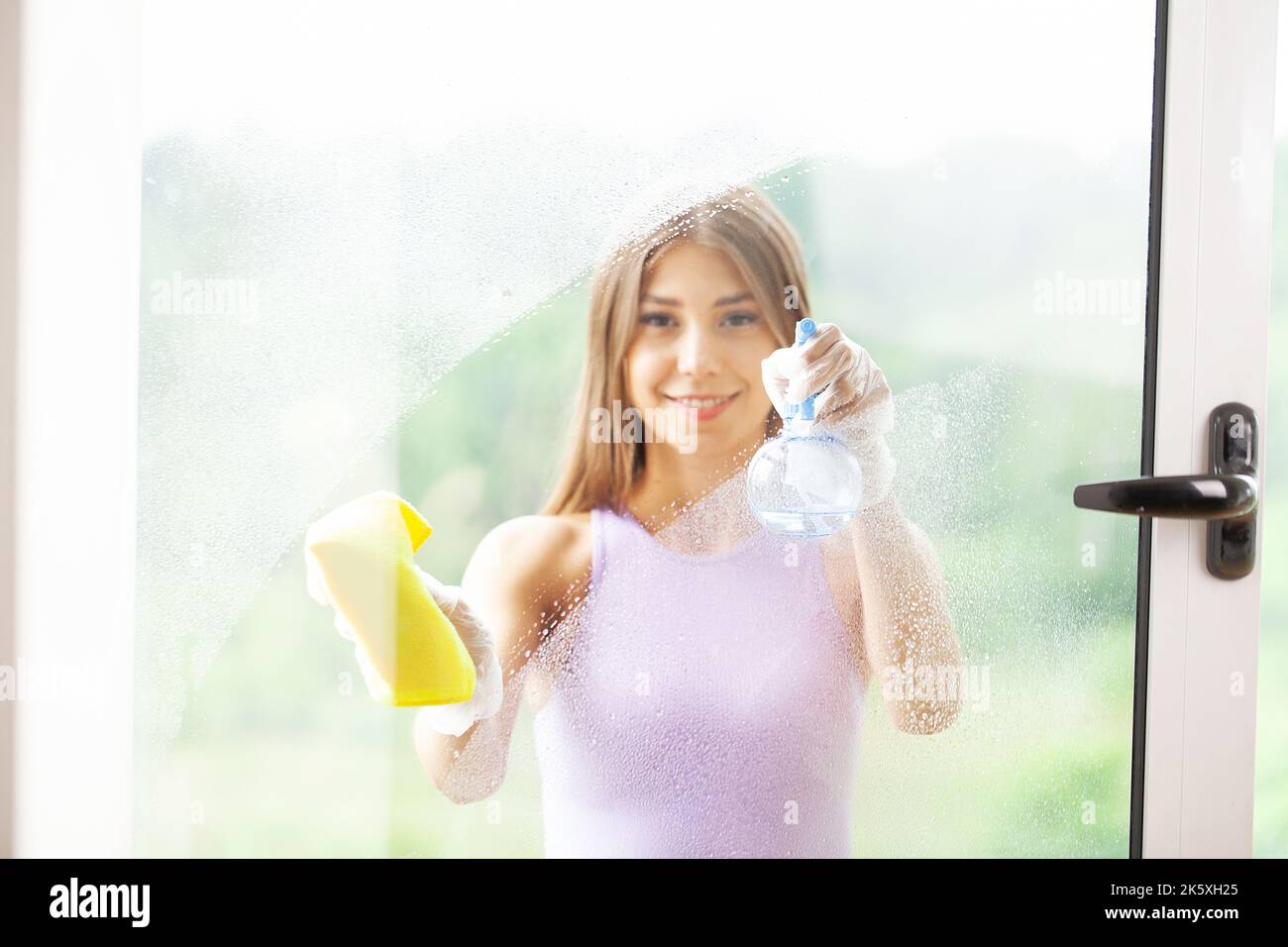Young Smiling Woman Washing Window with Sponge Stock Photo - Alamy