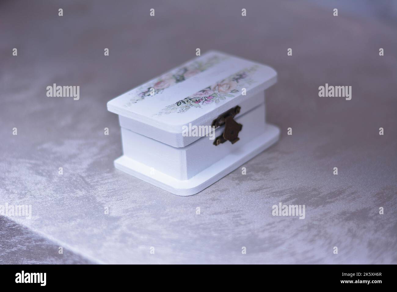 A closeup shot of a white box for accessories with a floral design on a ...