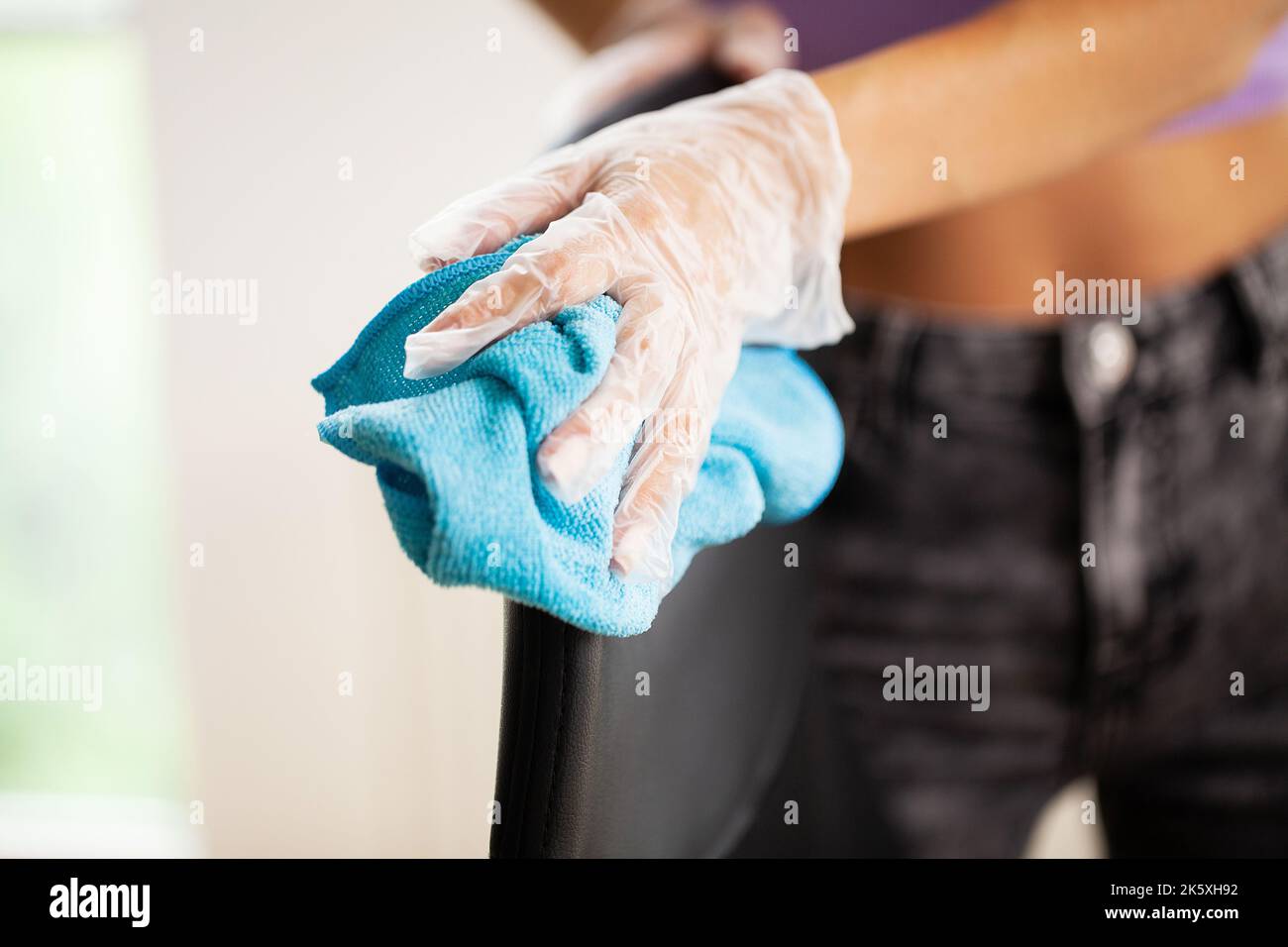 A cleaner cleans the office by wiping dust from an office chair Stock ...