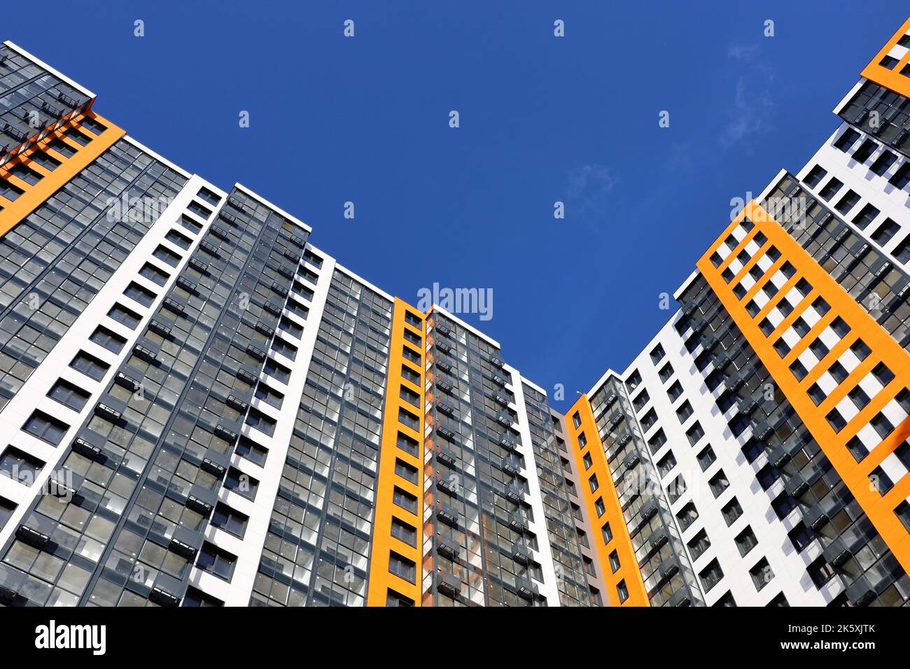 New residential building with orange and white cladding against blue ...
