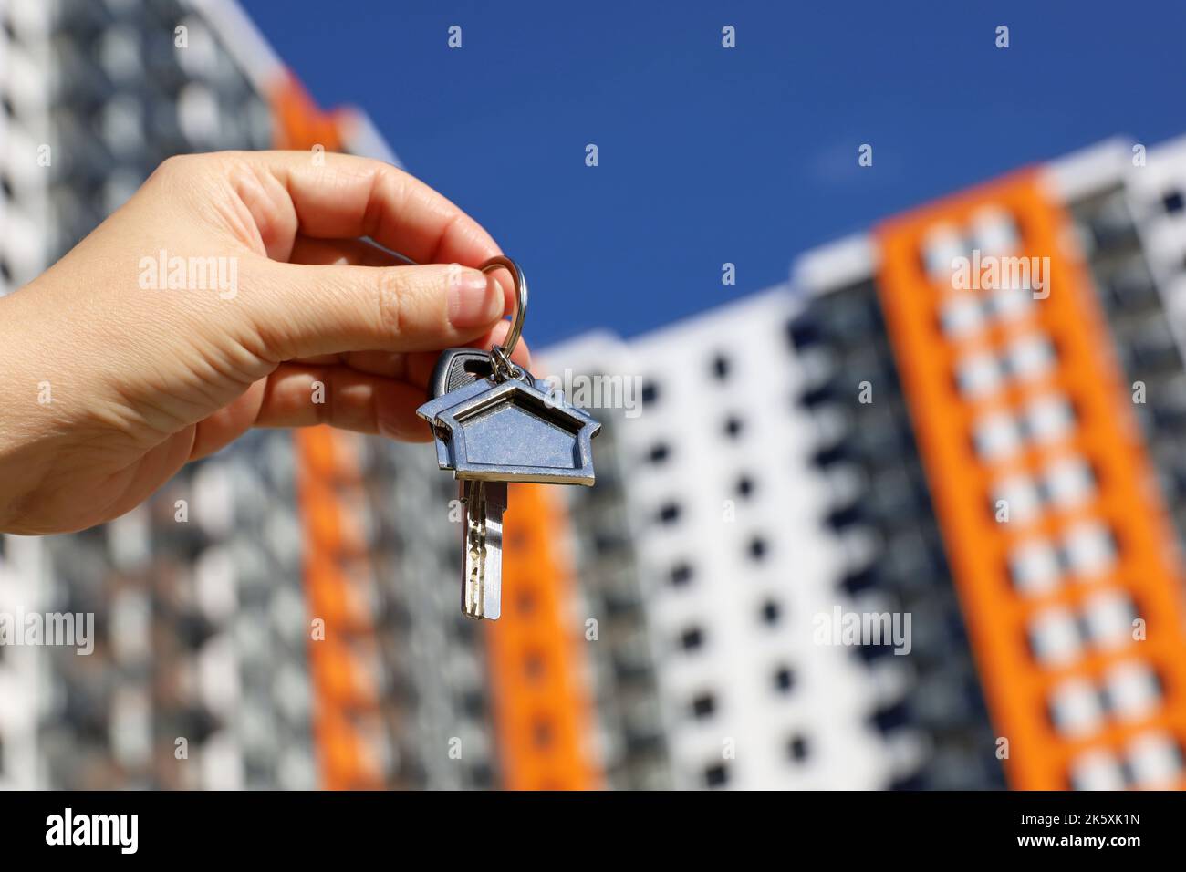 Real estate agent, home keys in female hand on background of new ...