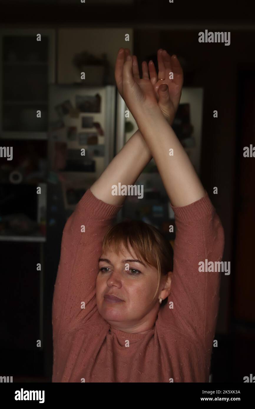 Defocus woman against dark indoor background, closeup on hands. Beauty ...