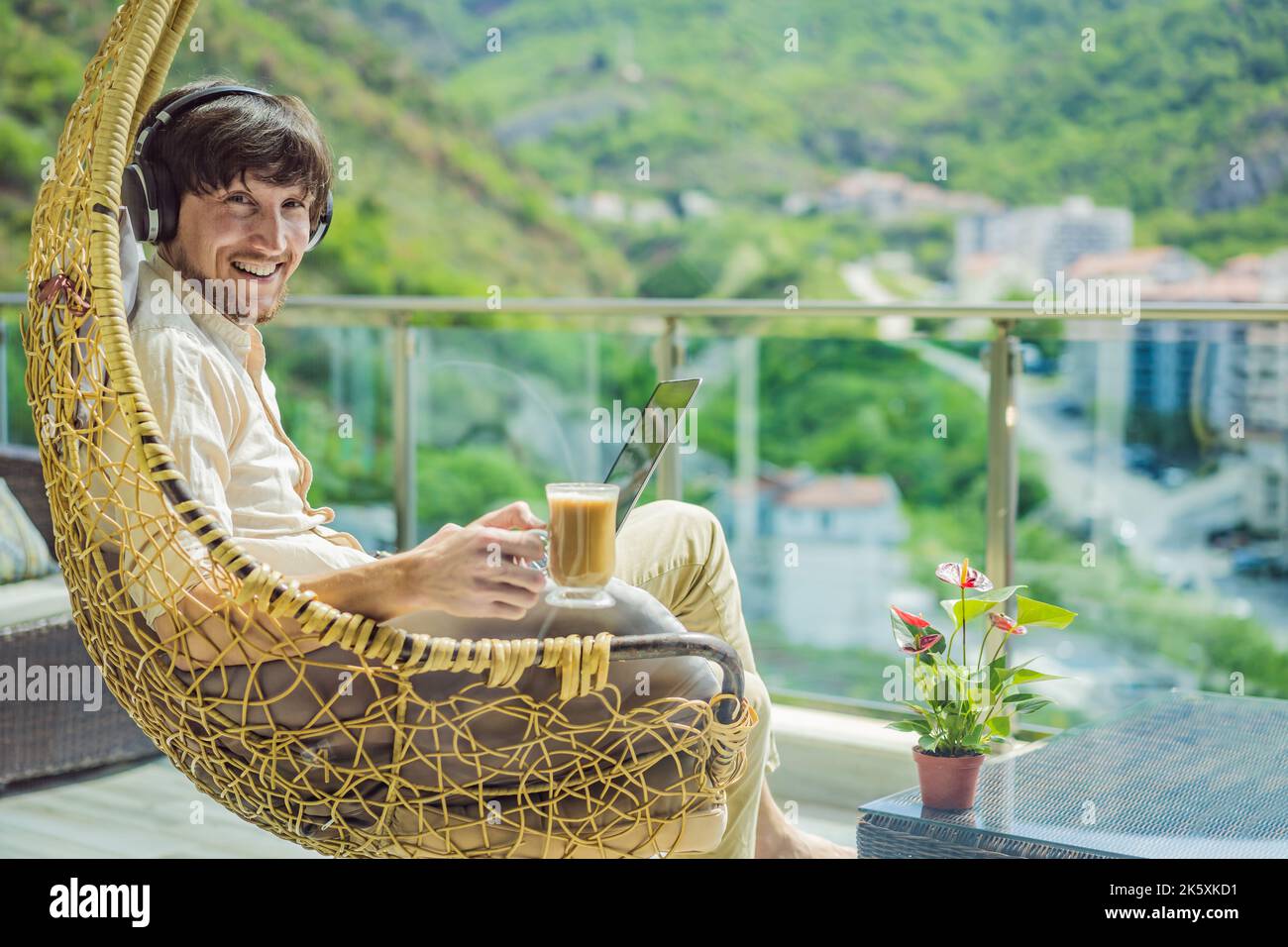 Handsome caucasian man sitting on the terrace working from home using ...