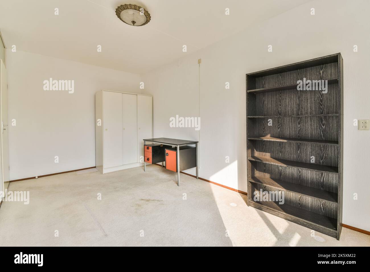 A cozy and spacious empty room with working desk and cupboard Stock ...