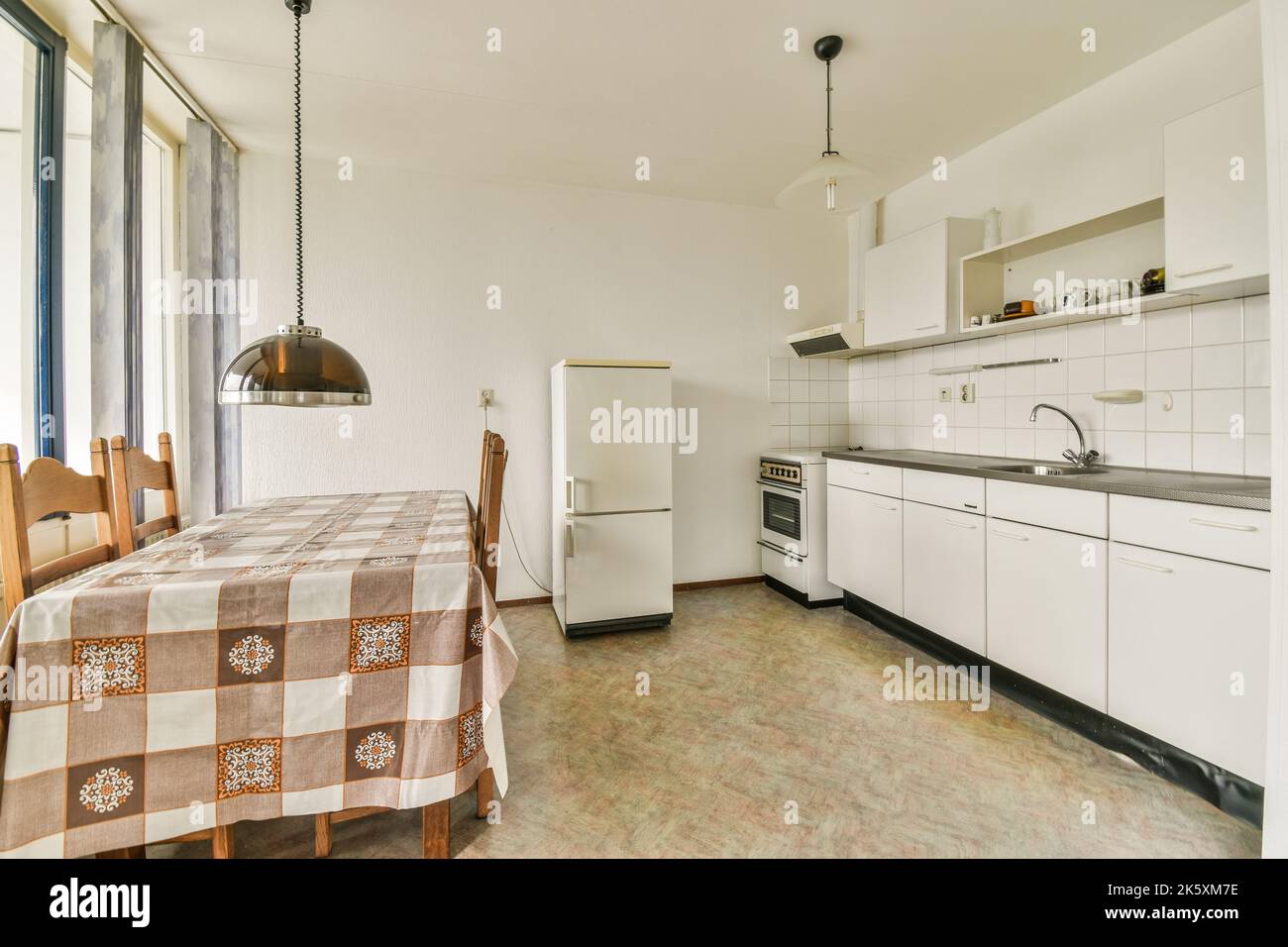 Interior of cozy open plan kitchen with built in appliances and ...