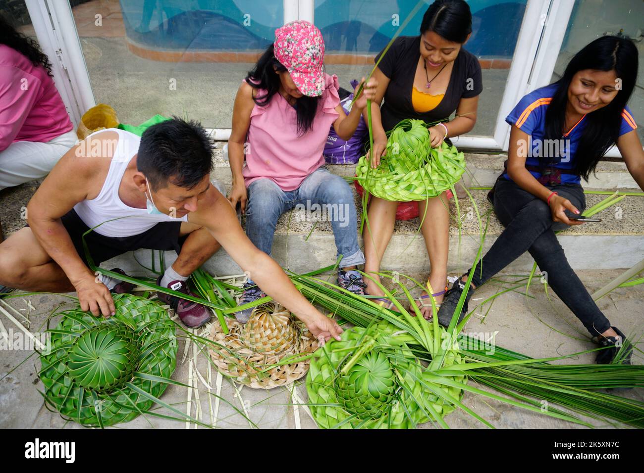 Family members making coconut palm leaf hats, Acapulco, Mexico Stock ...
